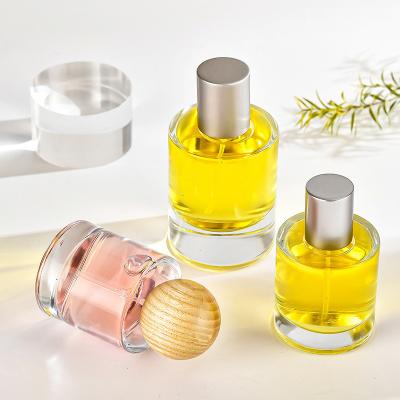 China Perfume Glass Bottle 50ml Bayonet Cylinder Transparent Spray Bottle with Wooden Cover for sale