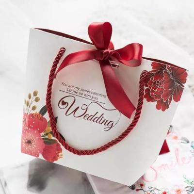 China Custom Logo Printed Paper Carrier Bags Luxury Wedding Gift Bags with Ribbon Closure 300gsm for sale