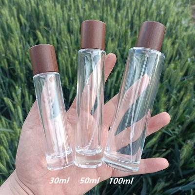 China 100ml Perfume Spray Atomizer Bottle Glass Empty Cylindrical Wooden Lid for sale