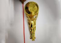China Shiny Gold Plated Custom Trophy Cup With The Statue Holding The Ball Design for sale
