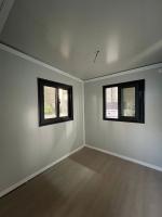 China 20ft Expandable Container House with Wood-Grain Cladding and Dark Grey Window Frames for sale