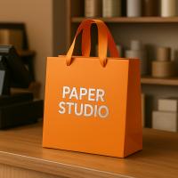 China Luxury Eco-Friendly Custom Logo Printing Silk Ribbon Handles Orange Paperboard Shopping Bags For Gift Clothing Boutique for sale