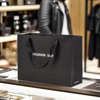 China Custom Logo Size Handmade Paper Gift Bags Embossed Folding Gift Big Black Paper Bag With Logo for sale