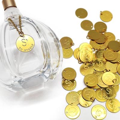 China Custom Luxury Gold Metal Charm Hang Tag Etching Embossed Logo for Perfume Bottle Decoration 16mm for sale