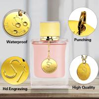 China Custom Luxury Gold Metal Charm Hang Tag Etching Embossed Logo for Perfume Bottle Decoration 16mm for sale