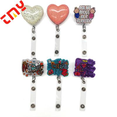 China Custom Acrylic Badge Reel Toppers 32mm Funny Cartoon Glitter Charms for Nurses Medical Staff for sale