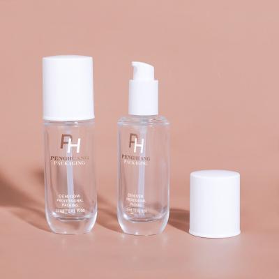 China Round Shape Clear Empty Liquid Foundation Bottle 30ml 1oz Glass Lotion Pump Bottle For Cosmetic Packaging for sale