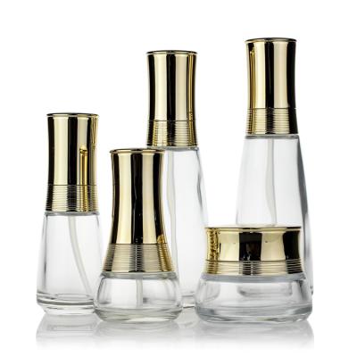 China 30ml 100ml 120ml Cosmetic Container Packaging Clear Glass With Gold Cap for sale