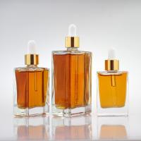 China Custom Logo Clear Glass Bottle 30ml 50ml 100ml with Gold Dropper for sale