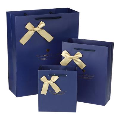 China Custom Navy Blue Luxury Packaging Bags with Gold Foil Printing and Satin Bow Detail - OEM/ODM Wholesale for sale