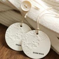 China Embossed Round Paper Hang Tags With Relief Floral Pattern For Apparel Branding for sale