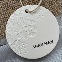 China Embossed Round Paper Hang Tags With Relief Floral Pattern For Apparel Branding for sale