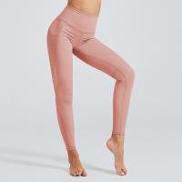 China Cell phone pocket yoga pants women hollow out stitching tight sports running fitness yoga pants for sale