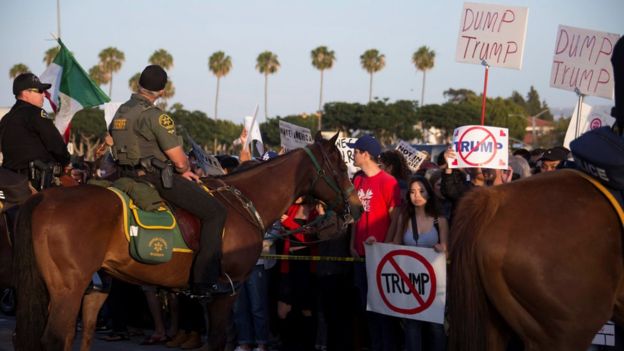 Police hold back Trump opponents in Costa Mesa, California, 28 April