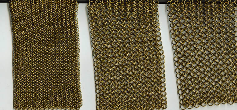 Three brass chainmail curtains on the track with different aperture sizes.