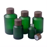 China 30g,50g,15ml,30ml,60ml,120ml, Green Frosted Glass Bottle With Wooden Screw Lid for sale