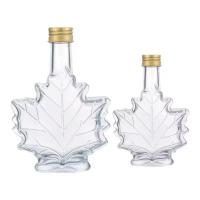 China Custom Color Industrial Glass Beverage Bottle with Maple Leaf Shape 50ml 100ml 250ml for sale