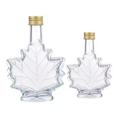 China Custom Color Industrial Glass Beverage Bottle with Maple Leaf Shape 50ml 100ml 250ml for sale