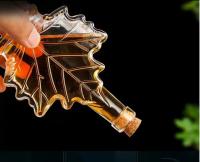 China Custom Color Industrial Glass Beverage Bottle with Maple Leaf Shape 50ml 100ml 250ml for sale