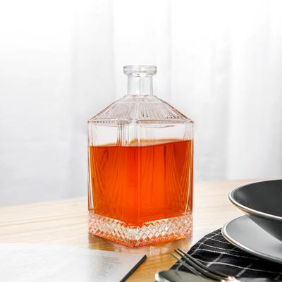 China Custom Embossed Logo 750ml Glass Bottle for Alcohol Spirits Clear Square Shape for sale