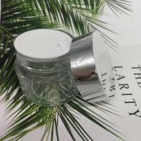 China MSDS Clear 100g Glass Cream Jar With Shiny Silver Cap White Lid Mask Mud for sale