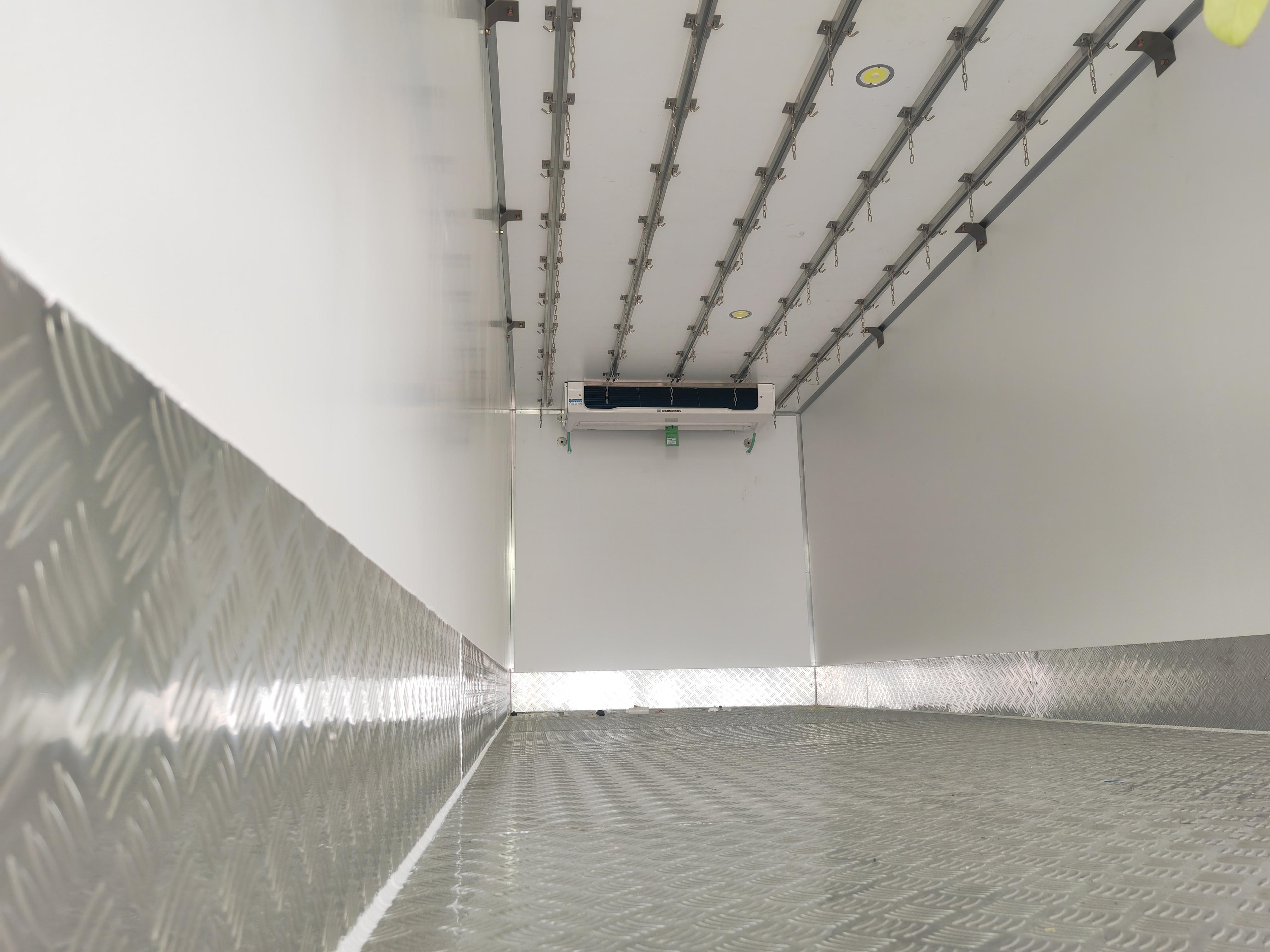 Inside refrigerated box body showing meat hanging hooks and aluminum diamond plate floor
