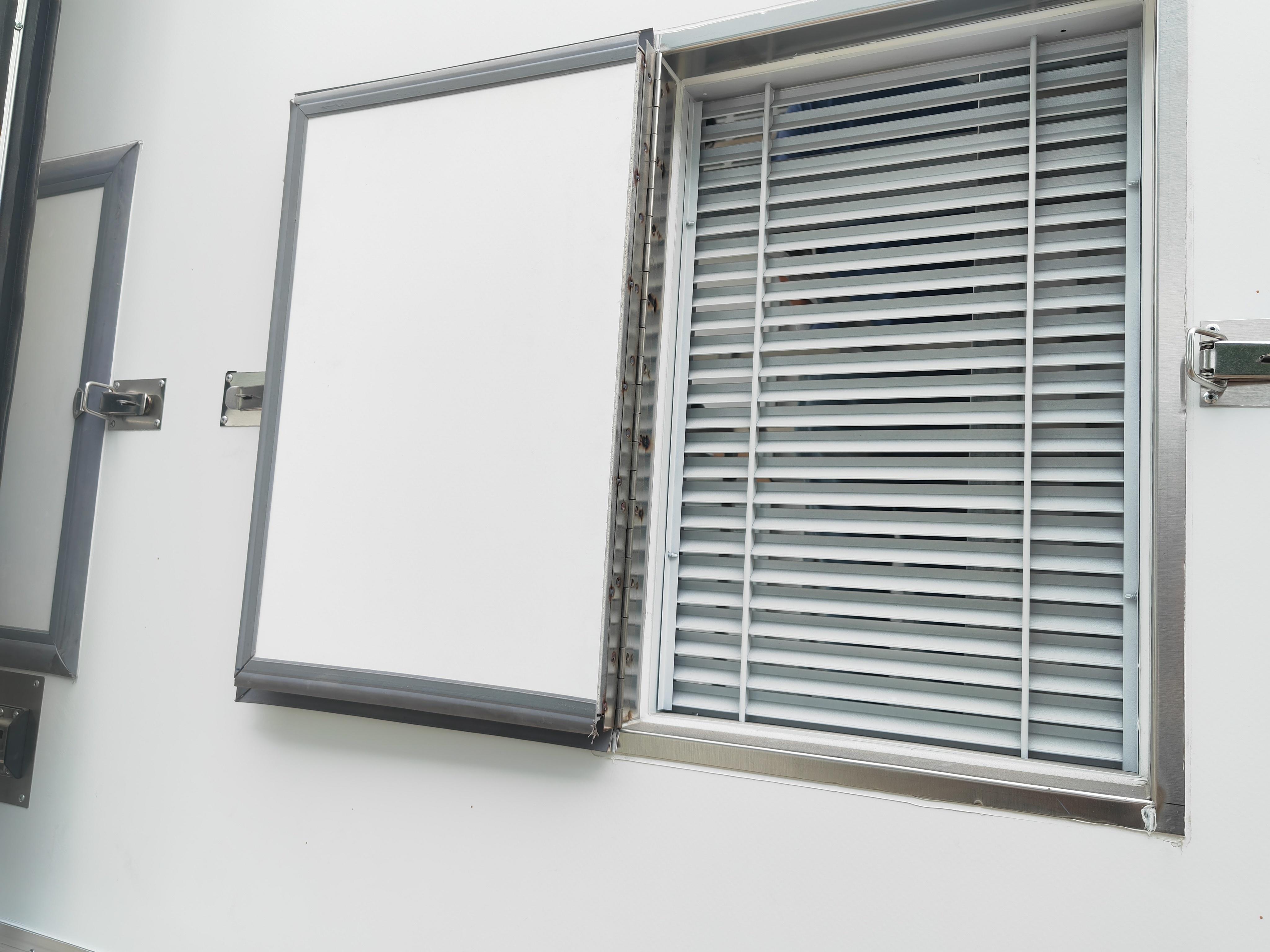 Detailed view of the opened side ventilation window with internal shutters on the poultry transport vehicle