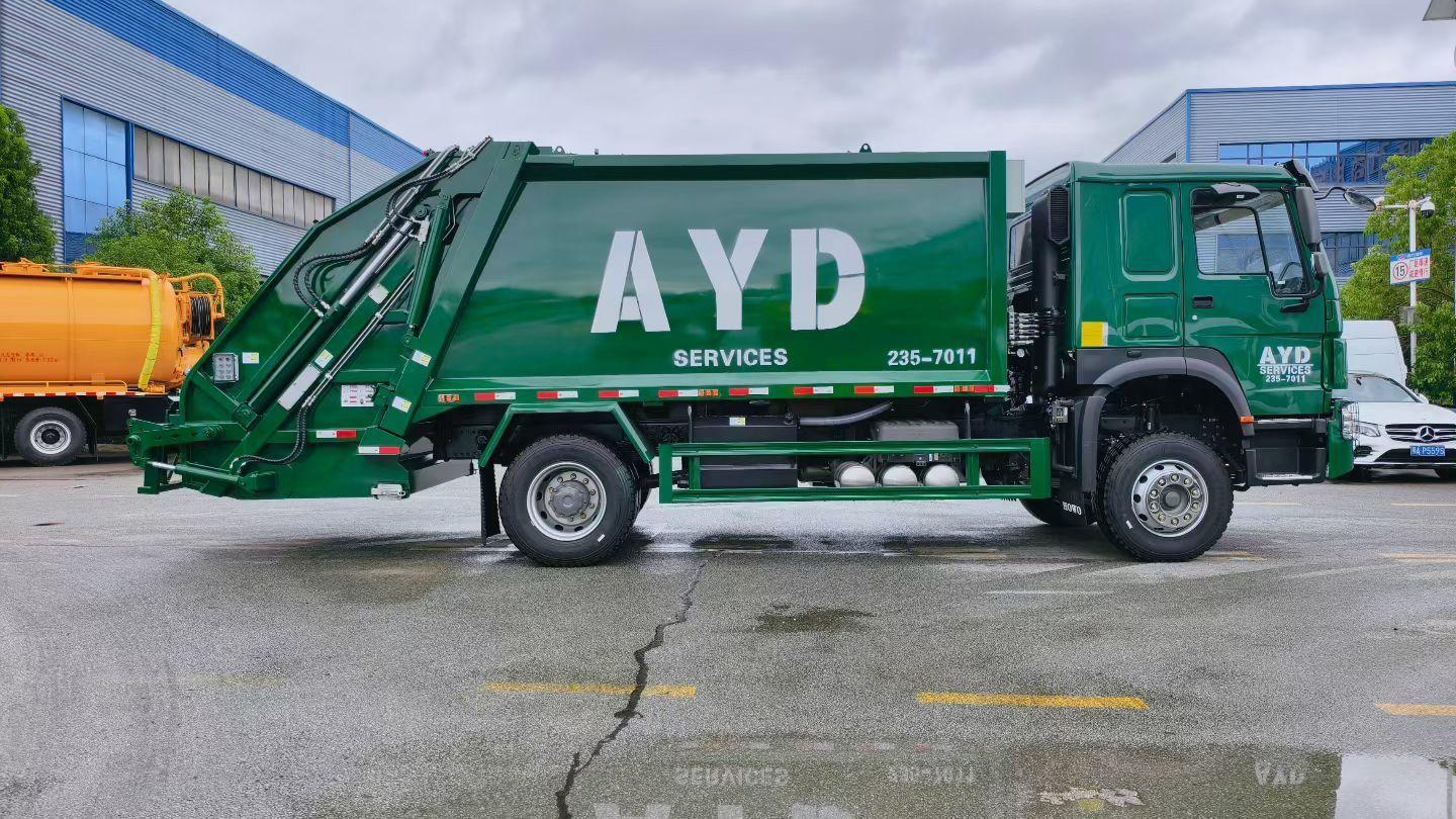 Sinotruk HOWO 15cbm compactor garbage truck side view for AYD Services Saipan