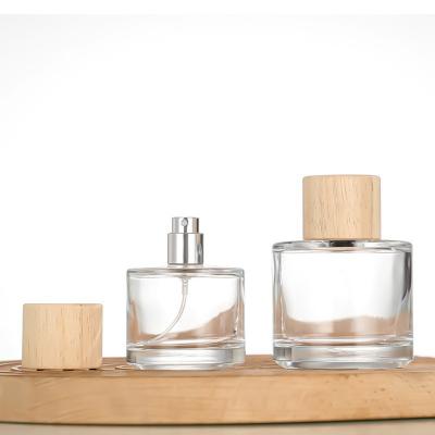 China Round Frosted Clear Glass Perfume Bottle 30ml 50ml 100ml with Wooden Cap for sale