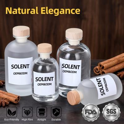 China Solent Luxury Round Frosted Clear Glass Bottle With Wooden Stopper Cork For Spirits for sale