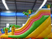 China Outdoor Park Game 2-Lane Tropical Palm Tree PVC Inflatable Dinosaur Jump Bounce Slide for sale