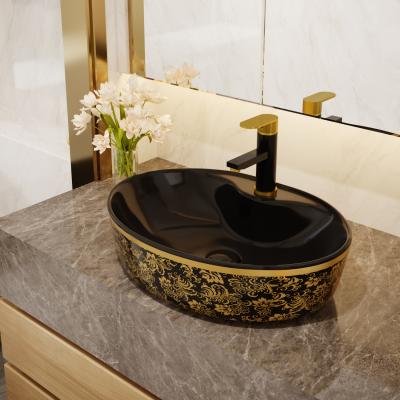 China Luxury Oval Freestanding Vanity Basin Black Gold Ceramic 560x410mm with Faucet for sale