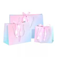 China Custom Logo Holographic Gift Paper Clothing Bags ISO Gradient Drawstring Paper Bag for sale