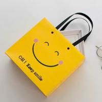 China ISO Shock Resistant Smile Face Kraft Paper Bags Yellow Square Bottom Paper Bag for sale