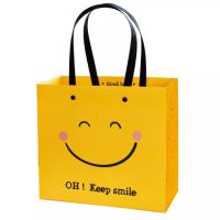China ISO Shock Resistant Smile Face Kraft Paper Bags Yellow Square Bottom Paper Bag for sale