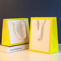 China Foldable Stand Up Ribbon Closure Kraft Paper Bags Paper Bag Packaging For Clothes for sale