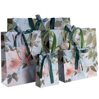 China Logo Printed Cosmetic 230gsm Present Paper Bags Twisted Rope Handle Paper Bags for sale