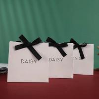 China Embossing Ribbon Handle Cosmetic Paper Bags White Paper Carrier Bags for sale