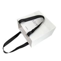 China Embossing Ribbon Handle Cosmetic Paper Bags White Paper Carrier Bags for sale