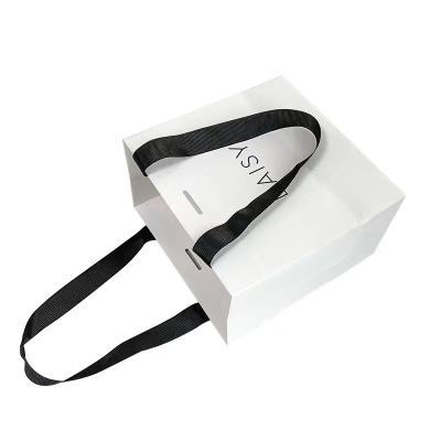 China Embossing Ribbon Handle Cosmetic Paper Bags White Paper Carrier Bags for sale