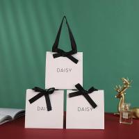 China Embossing Ribbon Handle Cosmetic Paper Bags White Paper Carrier Bags for sale