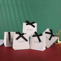 China Embossing Ribbon Handle Cosmetic Paper Bags White Paper Carrier Bags for sale
