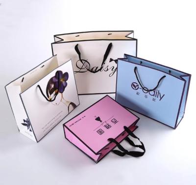 China Cosmetics Three Sections Rope Apparel Paper Bag Ivory Board Boutique Packaging Bags for sale
