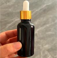 China 60ml Black Round Glass Dropper Bottle with Gold Collar for Essential Oil and Skin Care for sale