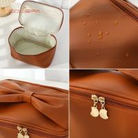 China PU Soft Leather New Arrival Travel Portable Makeup Bags Storage Large Capacity Waterproof Stylish Bow Handle Cosmetic Bag for sale