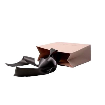 China Luxury Printed Custom Logo Clothing Gift Paper Packaging Bags with Hand Length Handle for sale