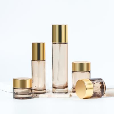 China Tea-colored glass cosmetic bottle with golden screw cap for skin care packaging in food-grade material for sale
