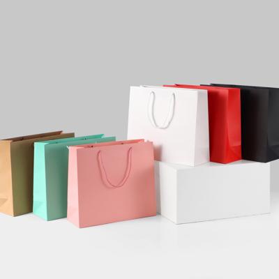 China Custom Luxury Clothing Retail Pink Gift Bag Shopping Packaging Paper Bags With Your Own Logo For Clothes for sale