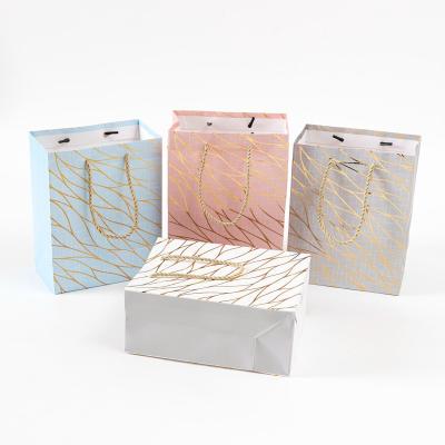 China Gold Foil Deep Embossed Paper Gift Bags For Festivals Gifting Business Favors for sale