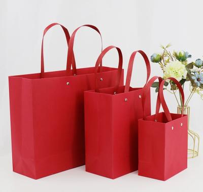China Luxury Red Rivet Handle Paper Bags Custom Logo Boutique Shopping Bags For Fashion Gifts for sale
